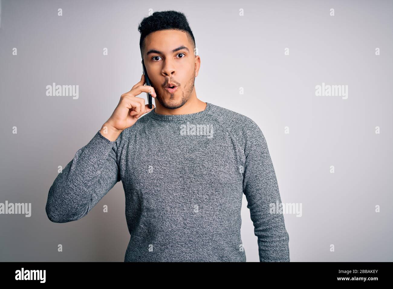 Young handsome man having conversation talking on the smartphone over ...