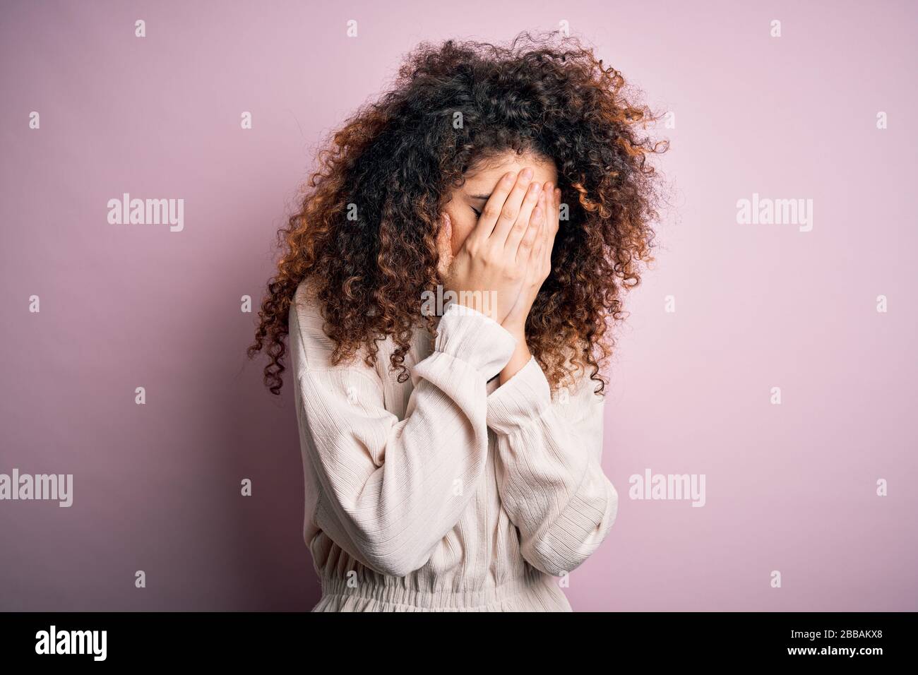 Beautiful woman with curly hair and piercing wearing casual sweater ...