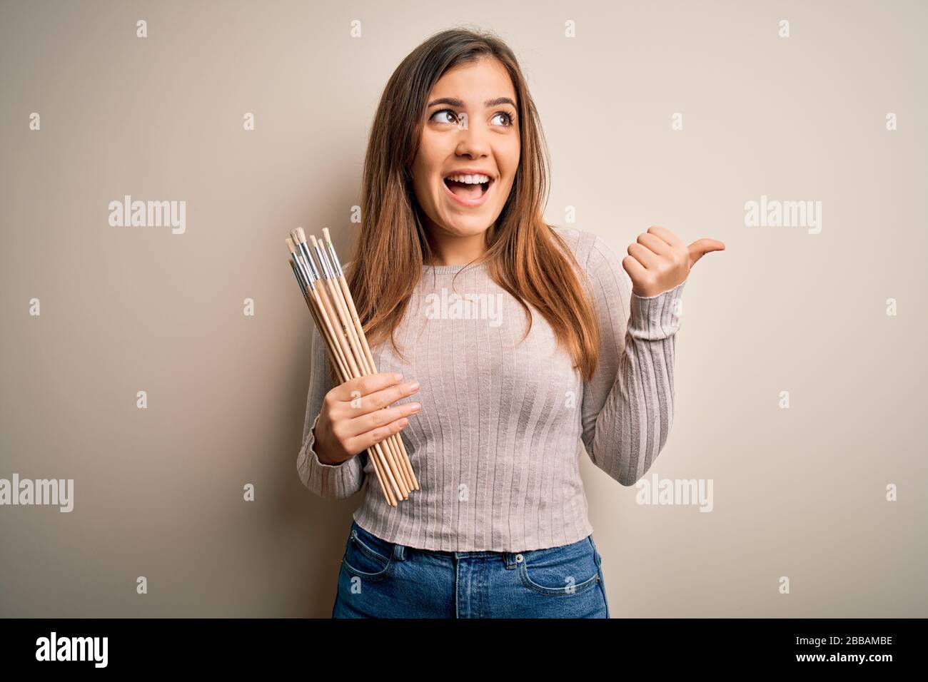Young painter artist woman painting using paintbrush over isolated ...