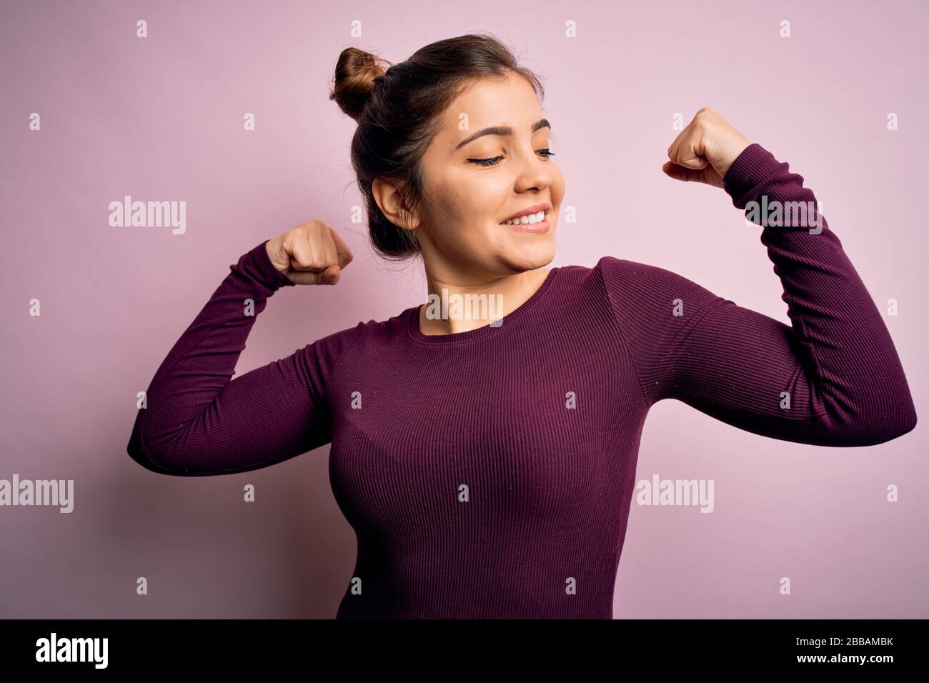 Beautiful young woman wearing casual bun hairstyle over pink isolated ...