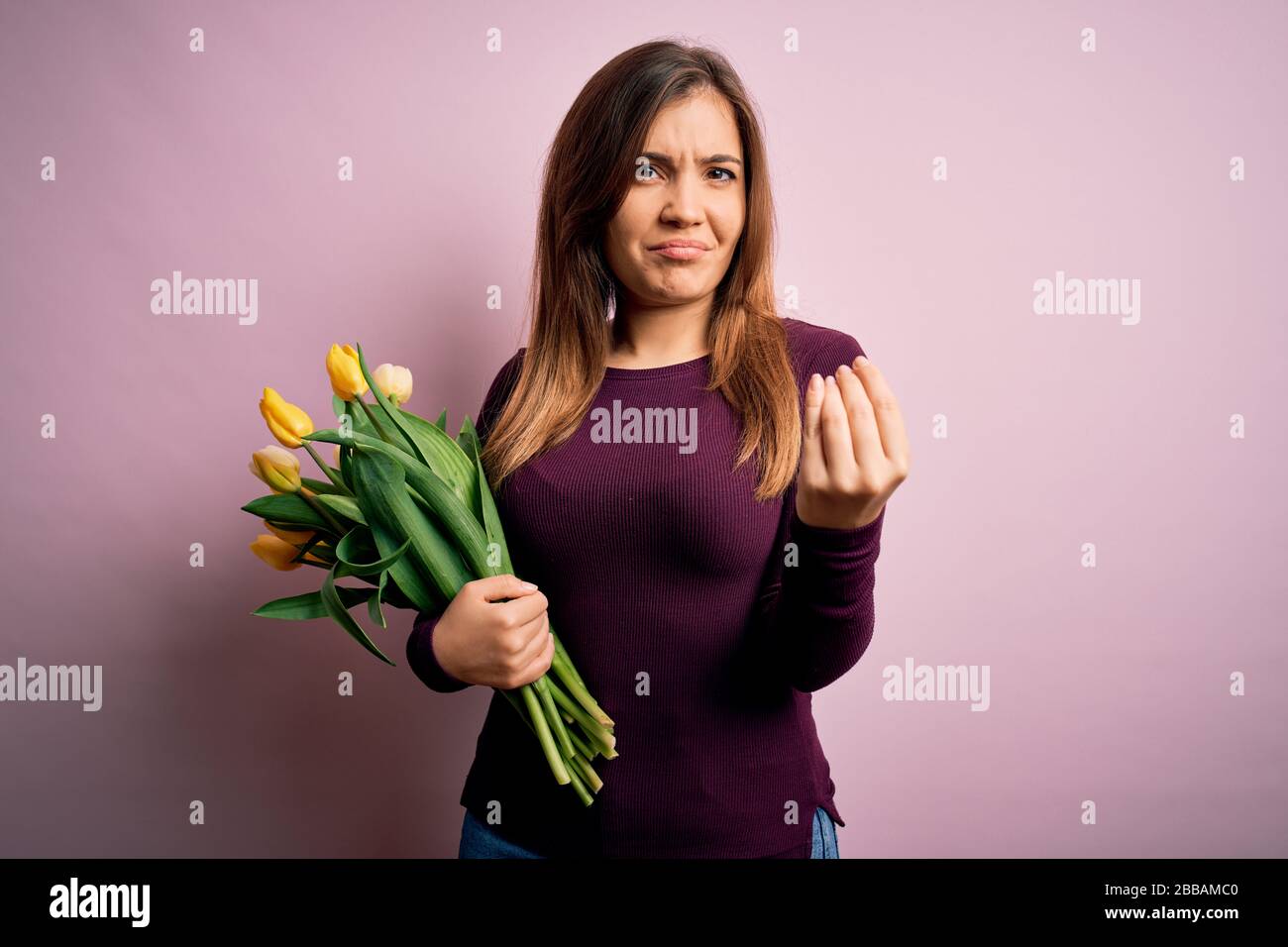 Young blonde woman holding romantic bouquet of yellow tulips flowers ...