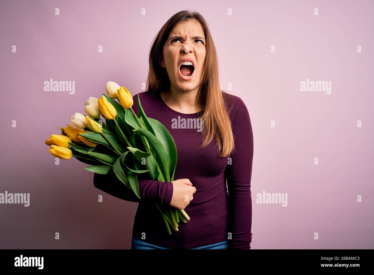 Young blonde woman holding romantic bouquet of yellow tulips flowers ...
