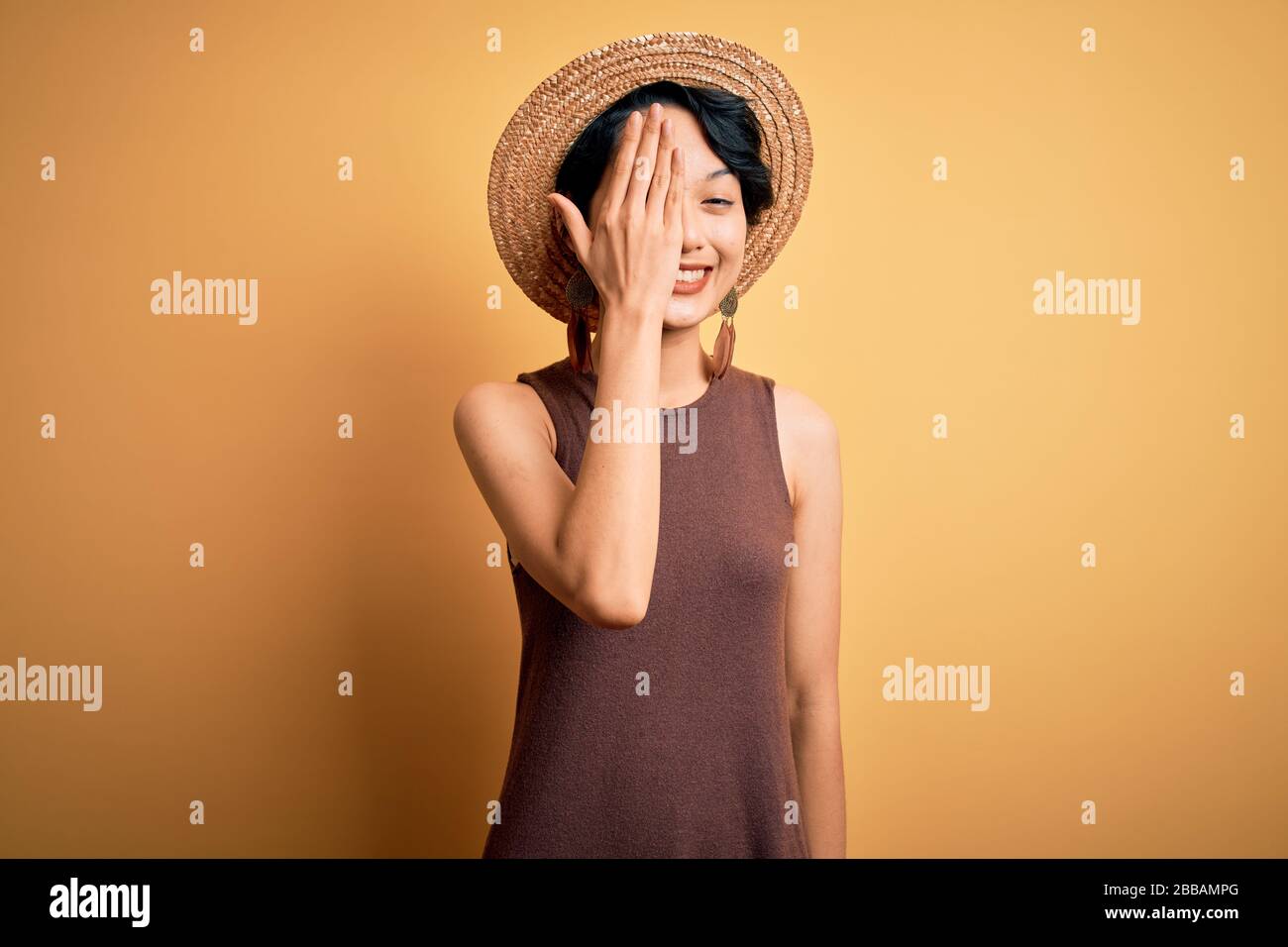 Young beautiful asian girl wearing casual t-shirt and hat over isolated ...