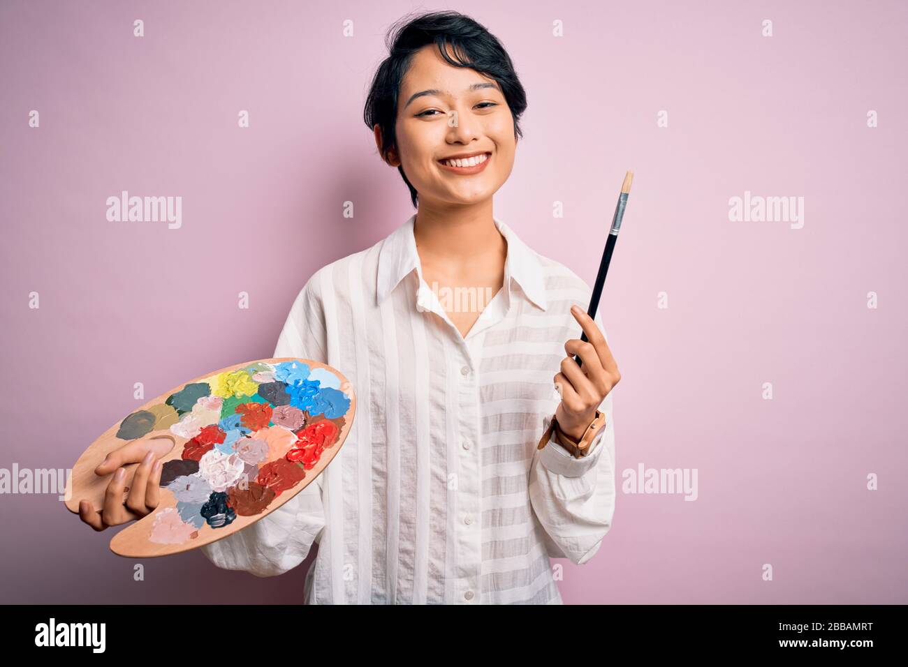 Young beautiful chinese artist woman painting using paintbrush and ...
