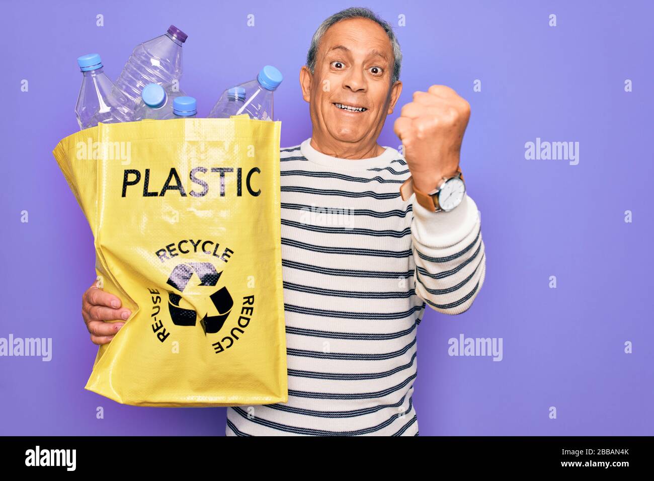 Senior man recycling holding bag with plastic bottles to recycle over ...