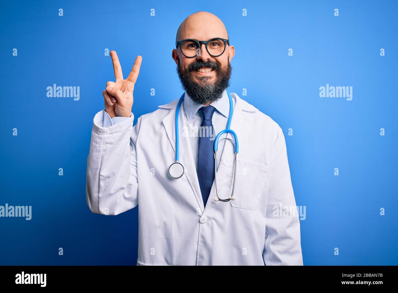 Handsome bald doctor man with beard wearing glasses and stethoscope ...
