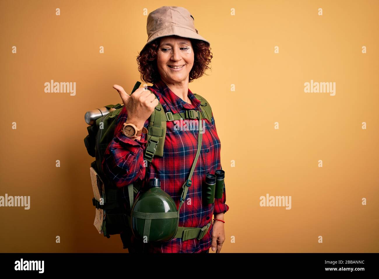 Middle age curly hair hiker woman hiking wearing backpack and water ...