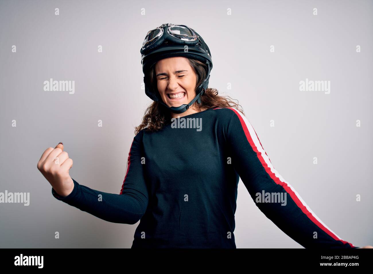 Beautiful motorcyclist woman with curly hair wearing moto helmet over ...