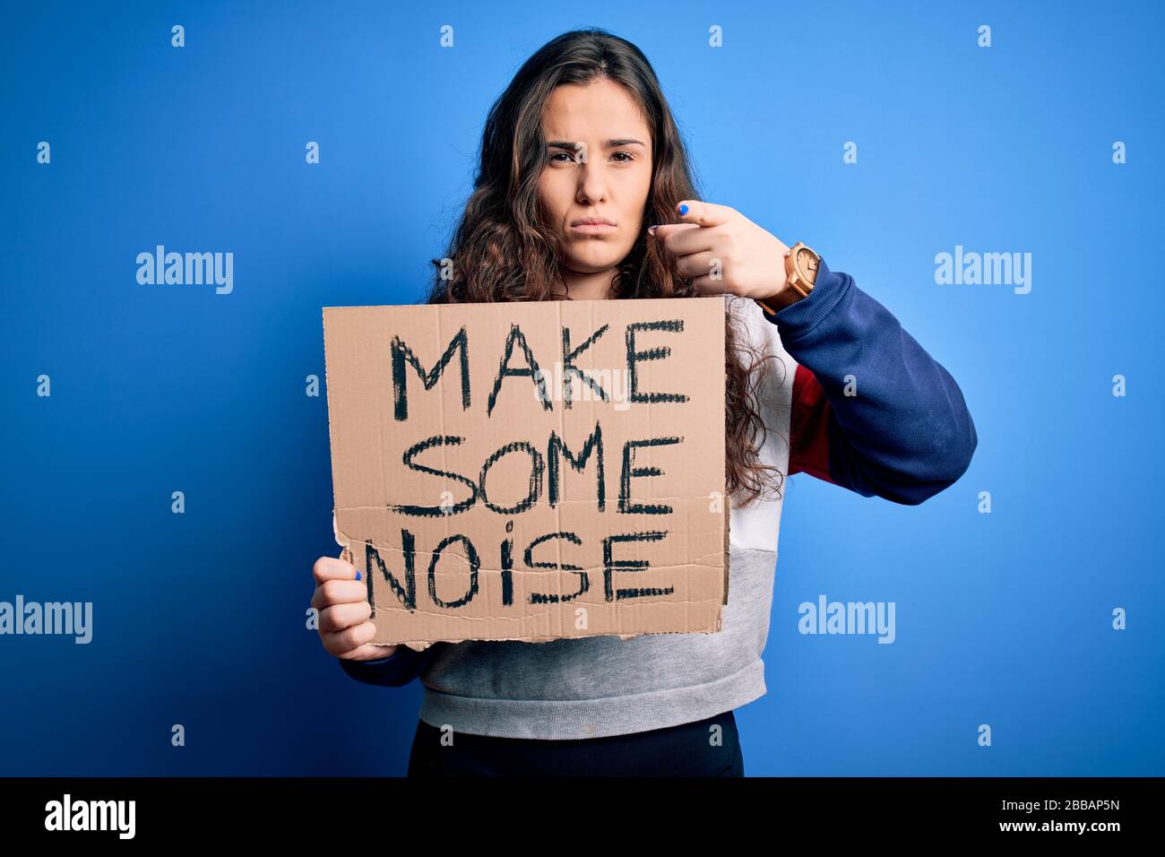 Beautiful activist woman holding banner with make some noise message ...