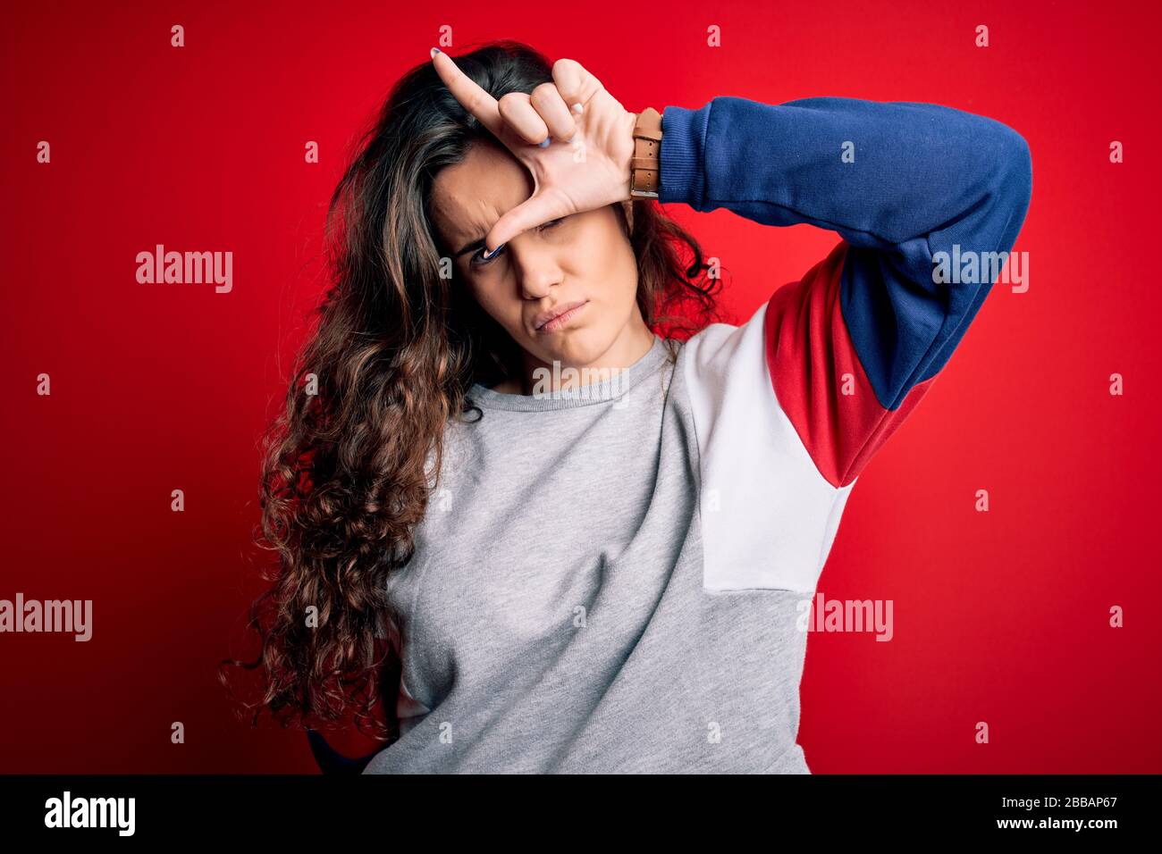 Young beautiful woman with curly hair wearing casual sweatshirt over ...