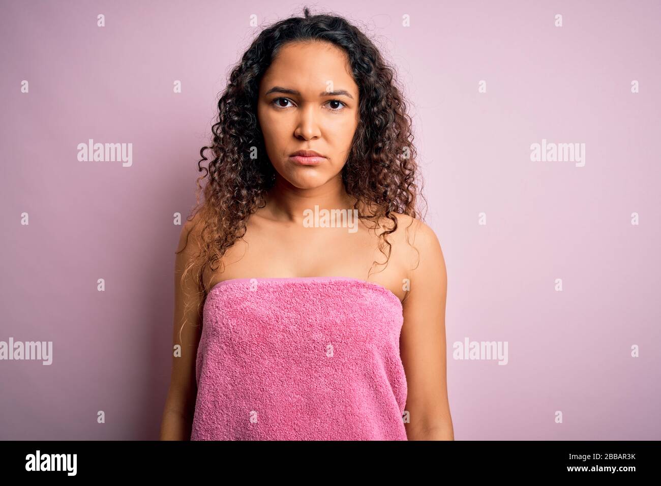 Young beautiful woman with curly hair wearing shower towel after bath ...