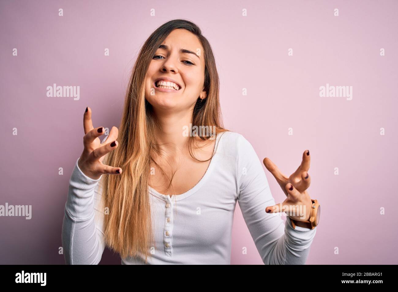 Young beautiful blonde woman with blue eyes wearing white t-shirt over ...