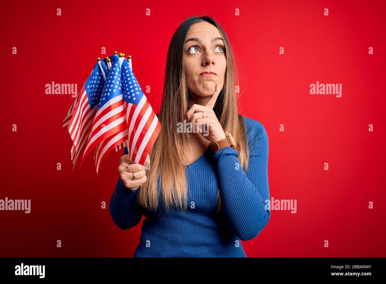 Young blonde patriotic woman holding usa flag on independence day on ...