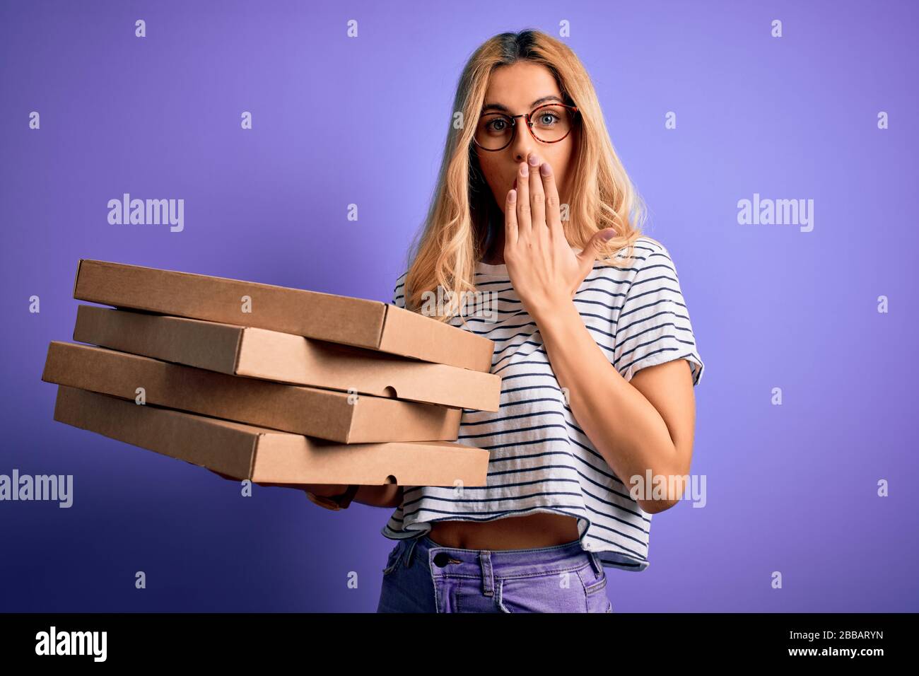 Young beautiful blonde woman holding boxes of italian pizza over ...