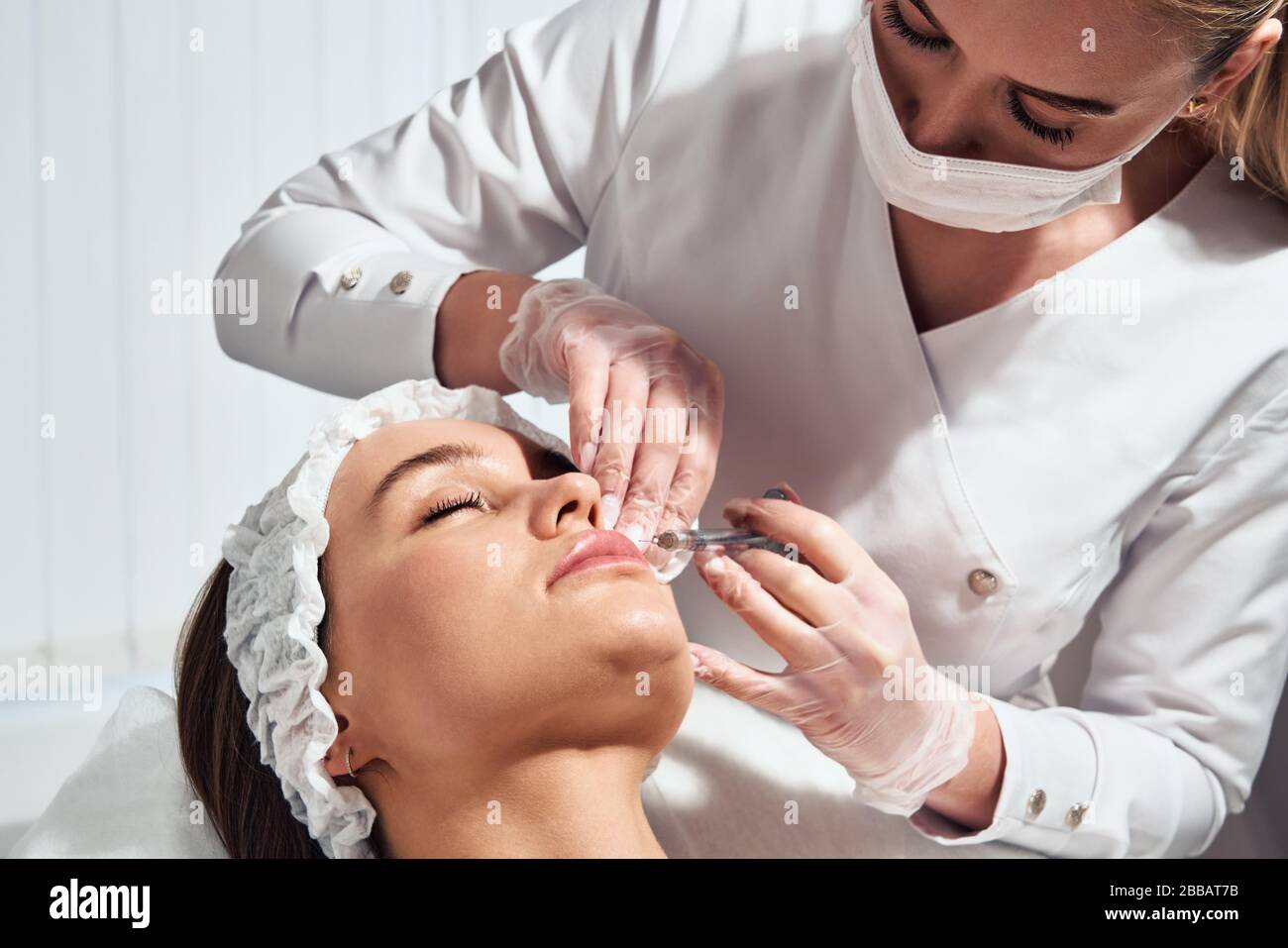 lip shape correction procedure in a cosmetology salon. The specialist ...