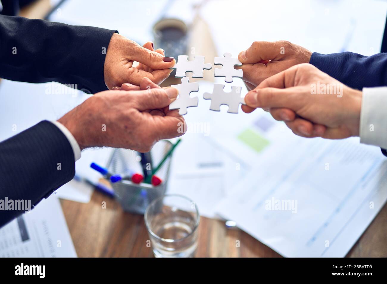 Group of business hands trying to connect puzzle pieces at office Stock ...