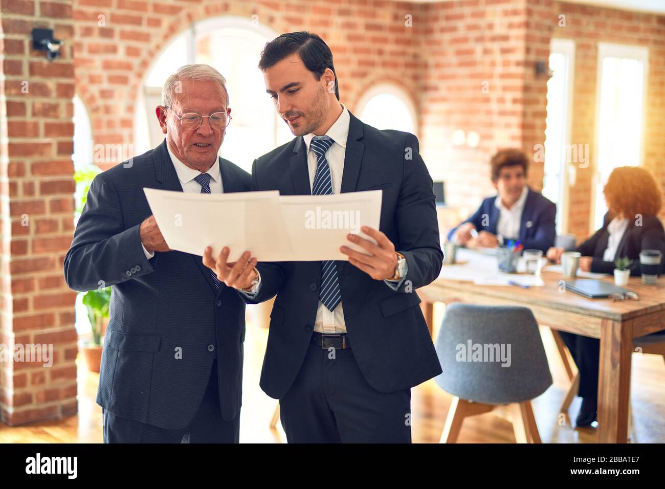 Two business workers working together. Speaking and reading documents ...