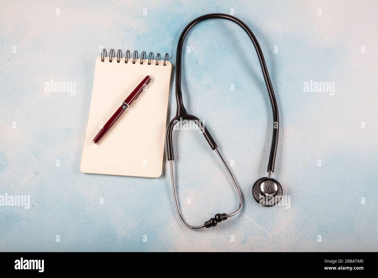 Prescription form clipped to pad lying on table with stethoscope and ...