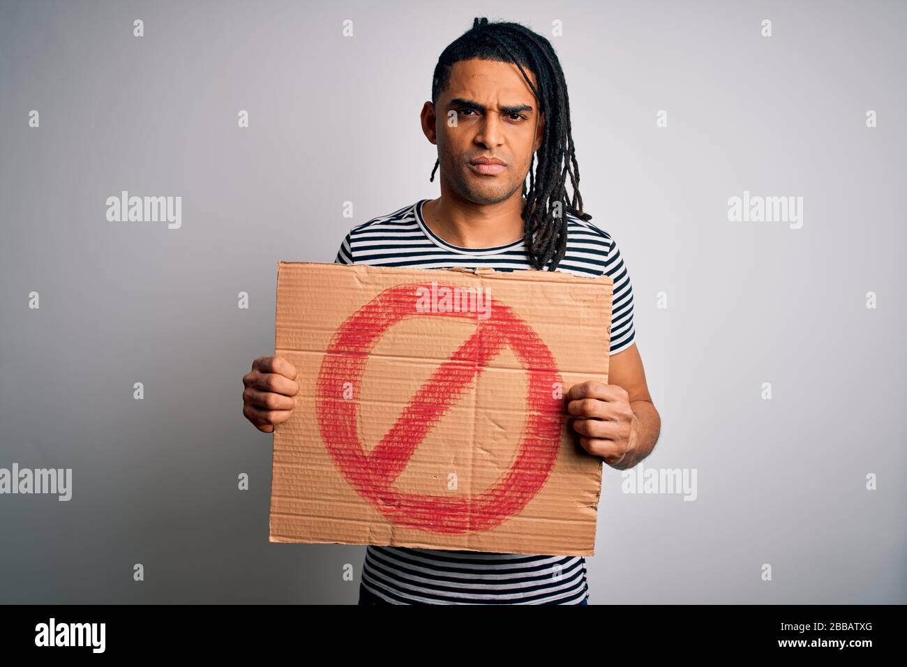 Young handsome african american man with dreadlocks holding banner with ...