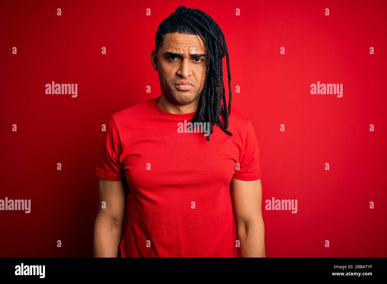 Young handsome african american afro man with dreadlocks wearing red ...