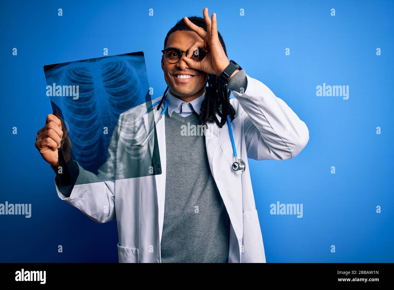 Young african american afro doctor man with dreadlocks holding chest ...