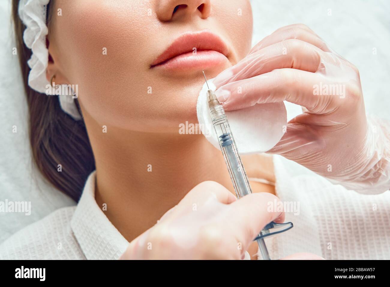 lip shape correction procedure in a cosmetology salon. The specialist ...