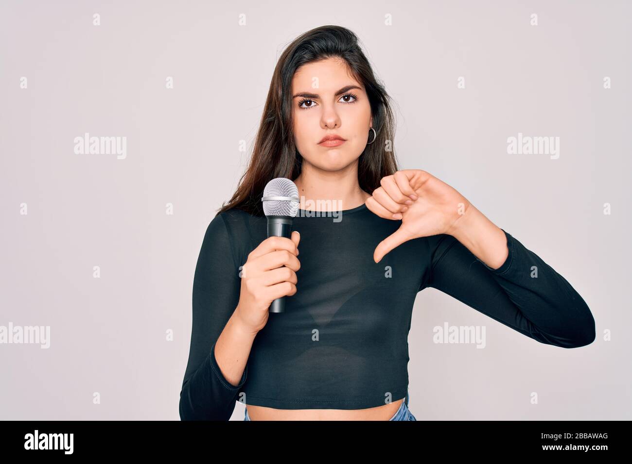 Young beautiful singer performer girl singing using music microphone ...