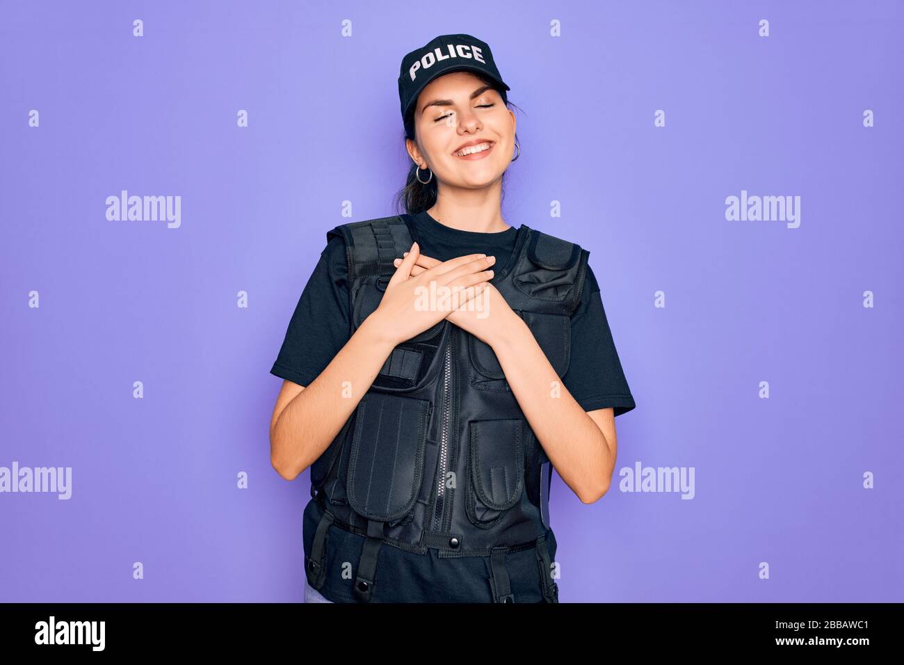 Young police woman wearing security bulletproof vest uniform over ...