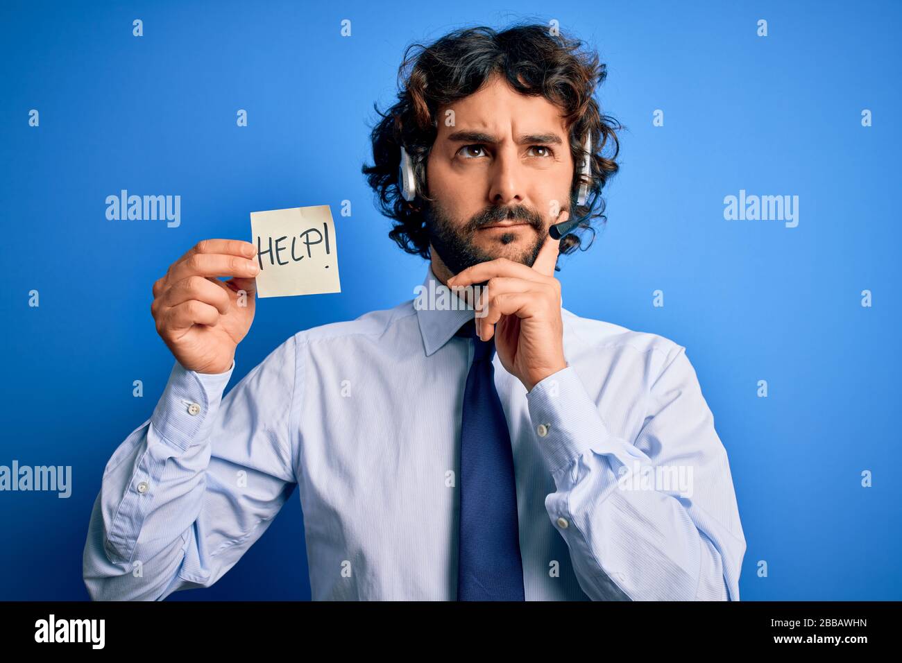 Young handsome call center agent man with beard working using headset ...