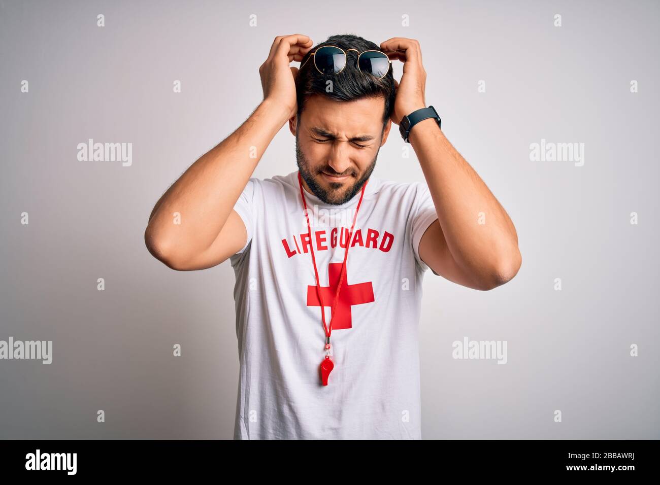 Young handsome lifeguard man with beard wearing t-shirt with red cross ...