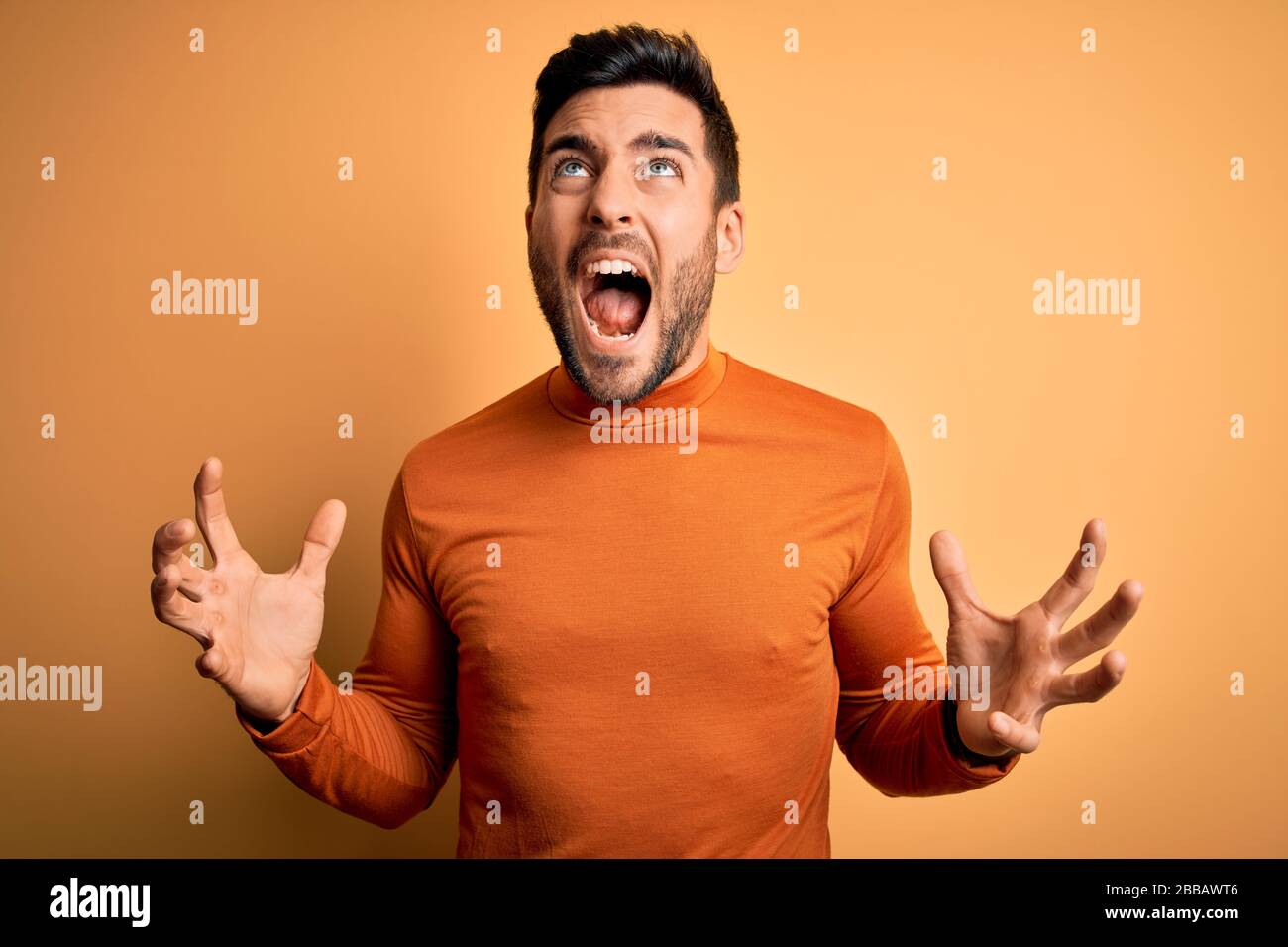 Young handsome man with beard wearing casual sweater standing over ...