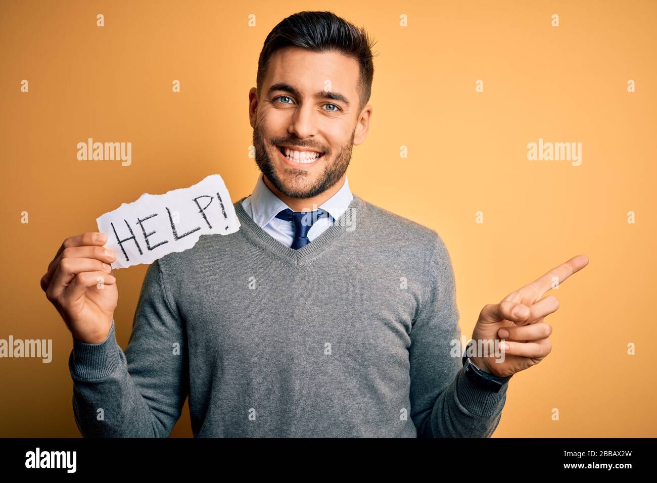Young overworked business man asking for help holding paper over yellow ...