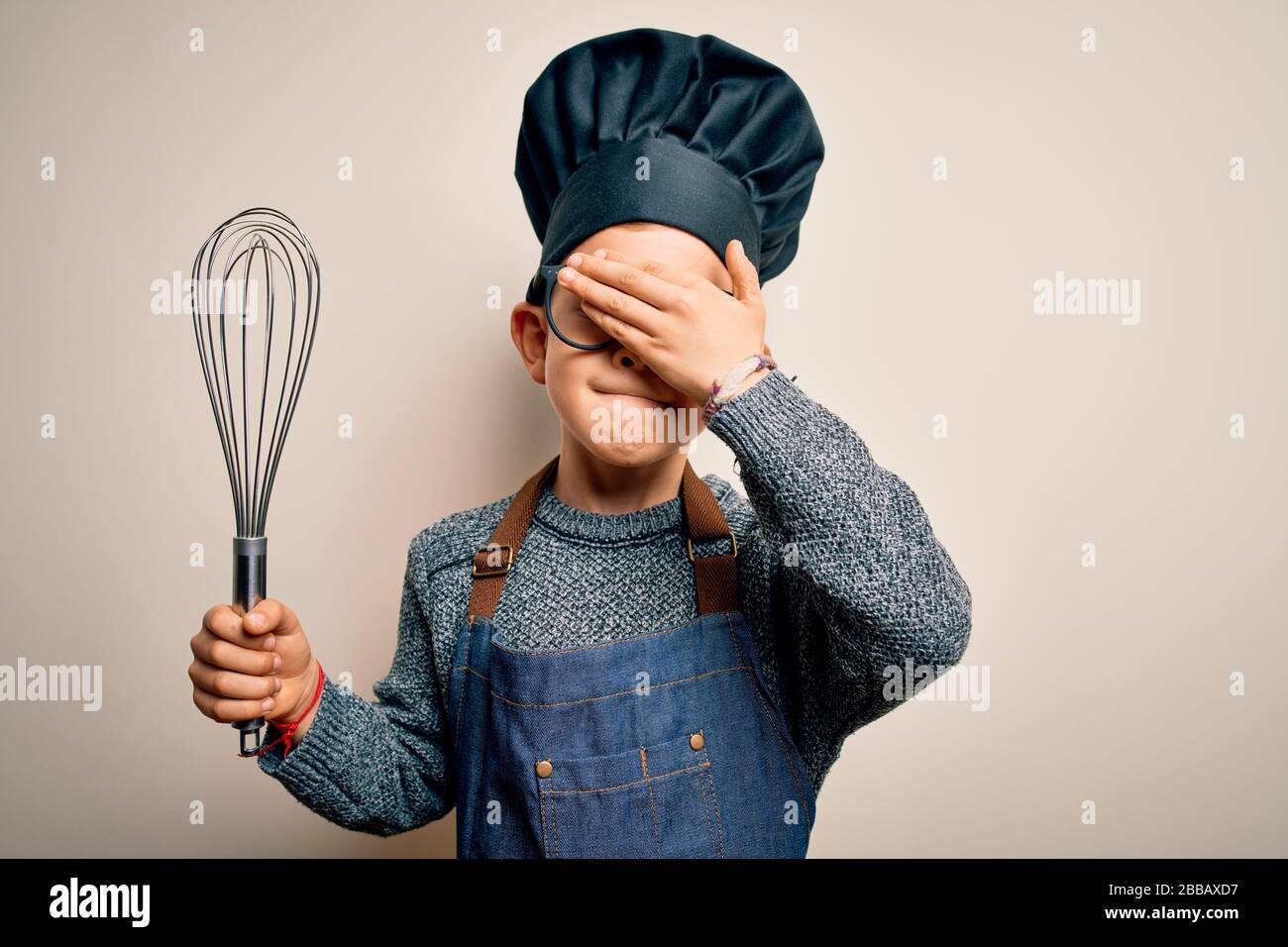 Young little caucasian cook kid wearing chef uniform and hat using ...