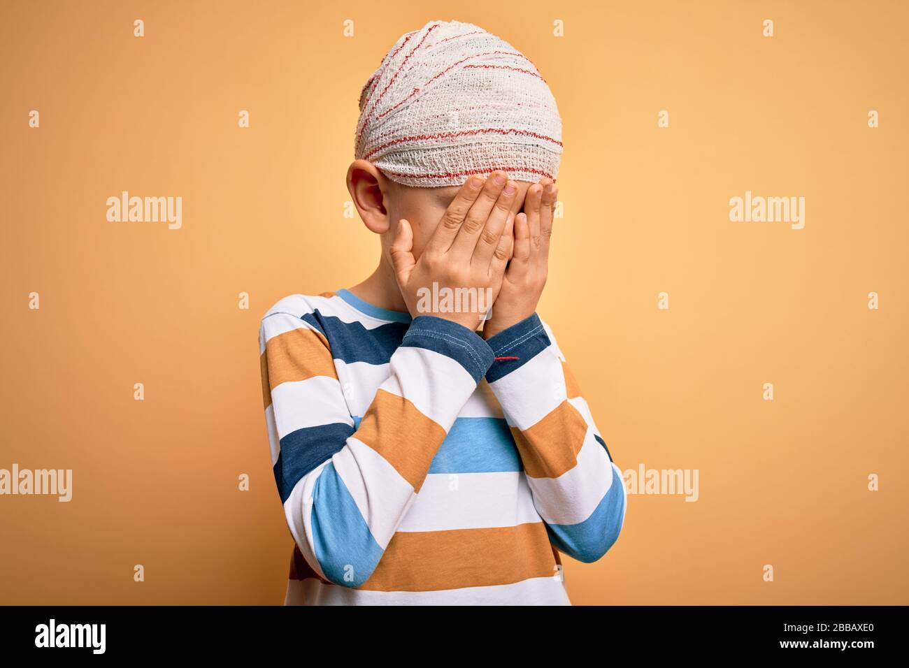 Young little caucasian kid injured wearing medical bandage on head over ...