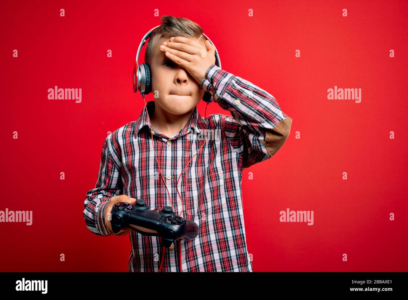 Young little caucasian gamer kid playing video games using gamepad ...