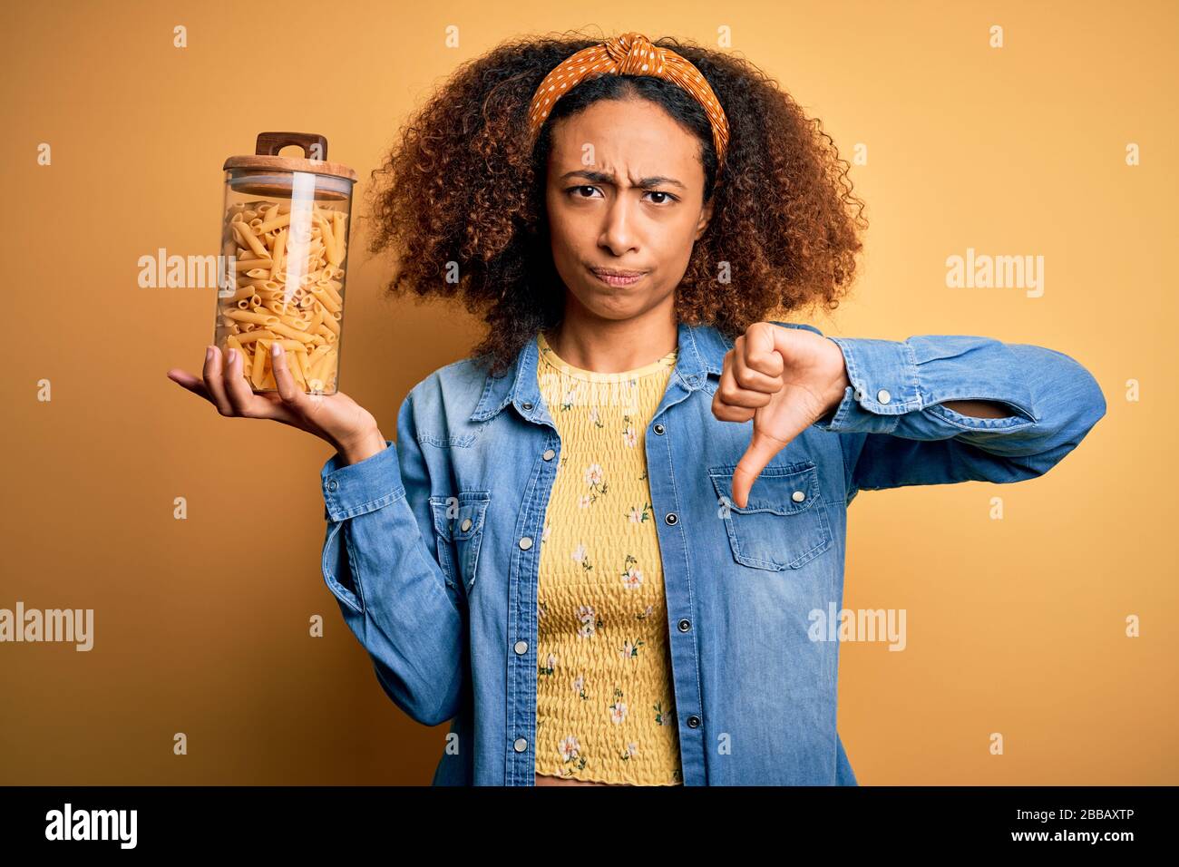 Young african american woman with afro hair holding jar with healthy ...