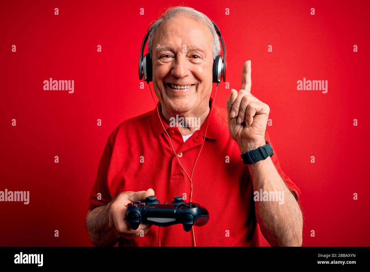 Senior grey haired gamer man playing video games using gamepad joystick ...
