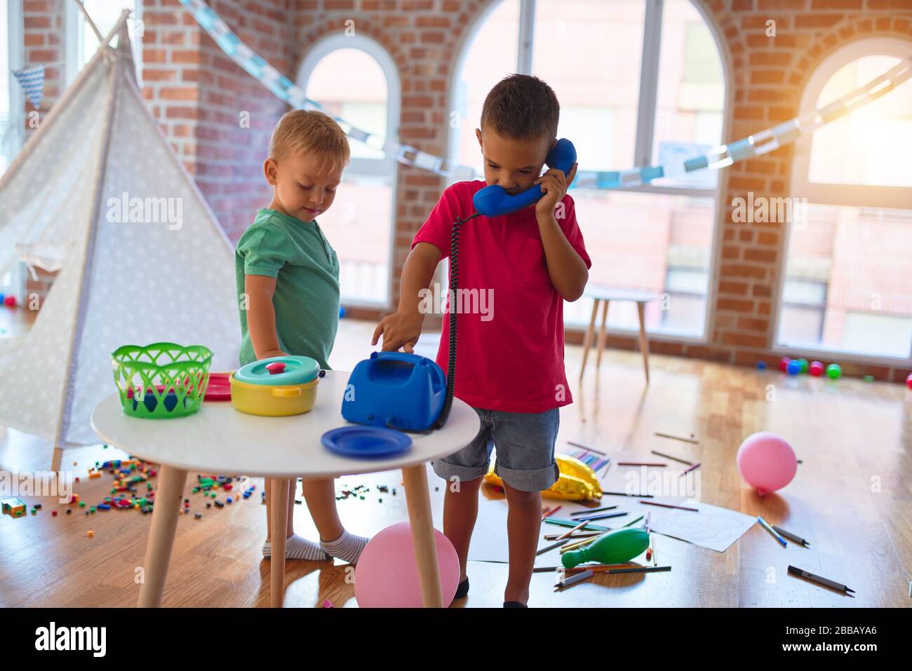 Adorable toddlers playing around lots of toys at kindergarten Stock ...