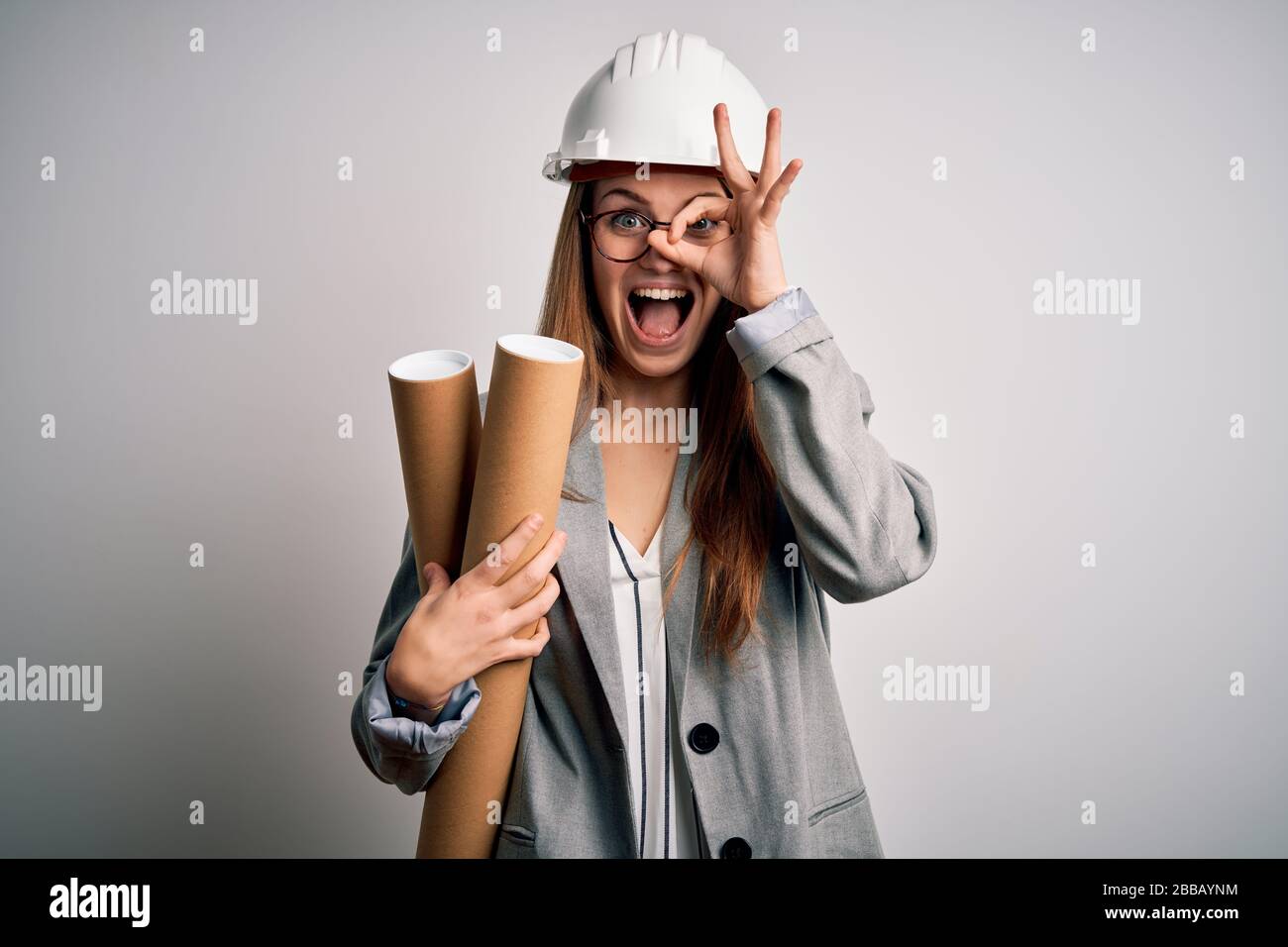 Young beautiful redhead architect woman wearing glasses and safety ... Young beautiful redhead architect woman wearing glasses and safety ...