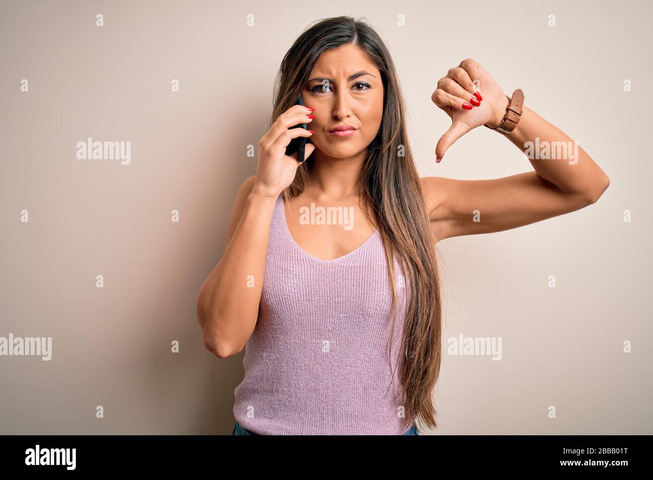 Young brunette woman having conversation talking on the smartphone over ...