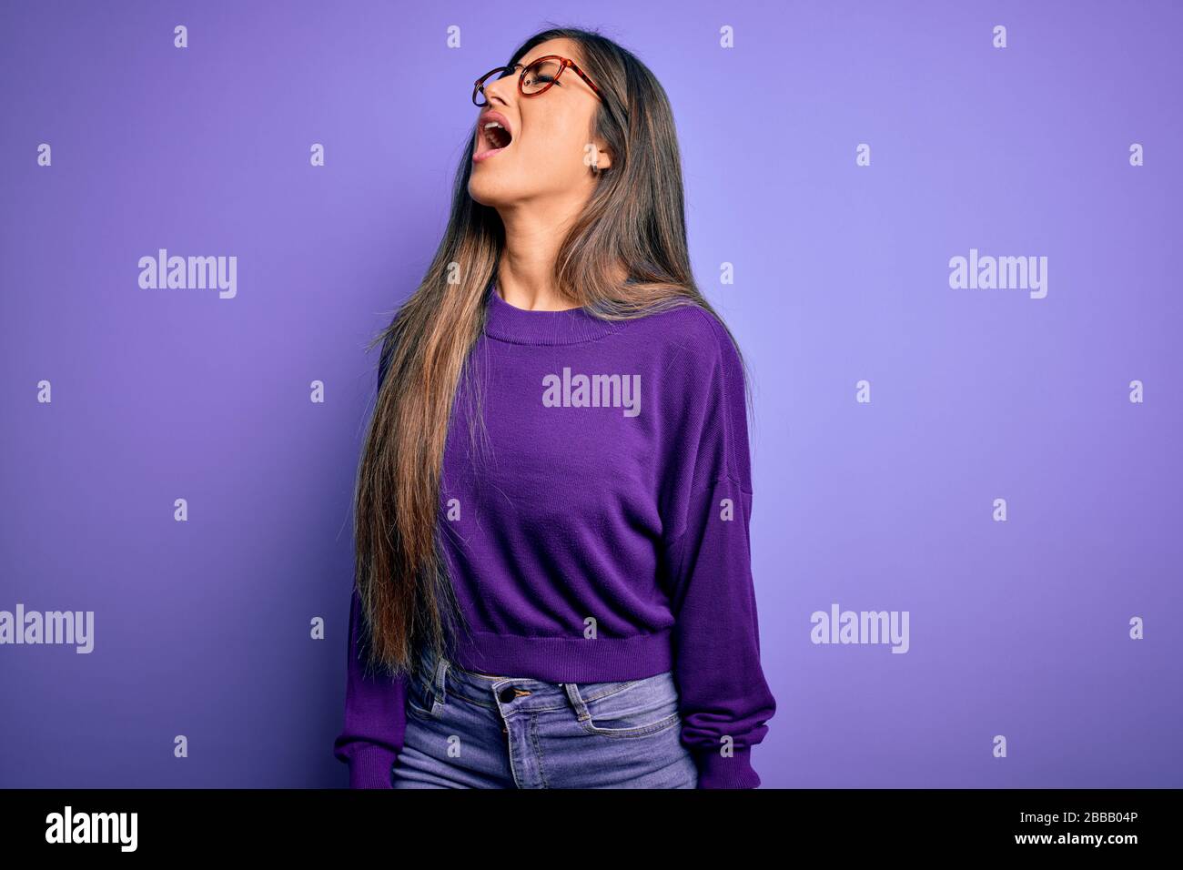Young beautiful smart woman wearing glasses over purple isolated ...