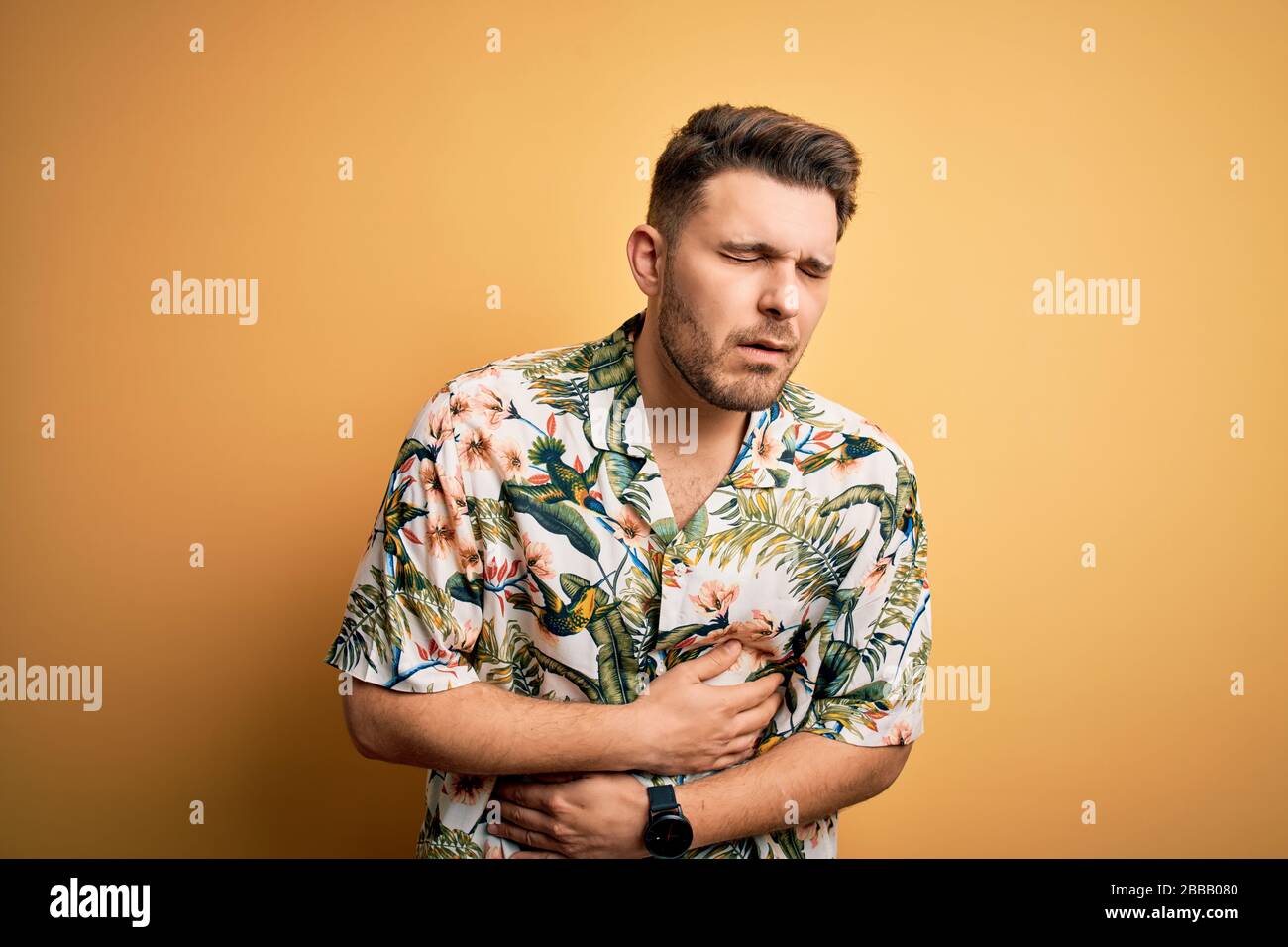 Young man with blue eyes on vacation wearing floral summer shirt over ...