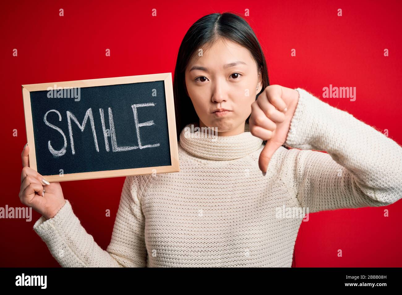 Young asian woman holding blackboard with smile word as hapinness ...