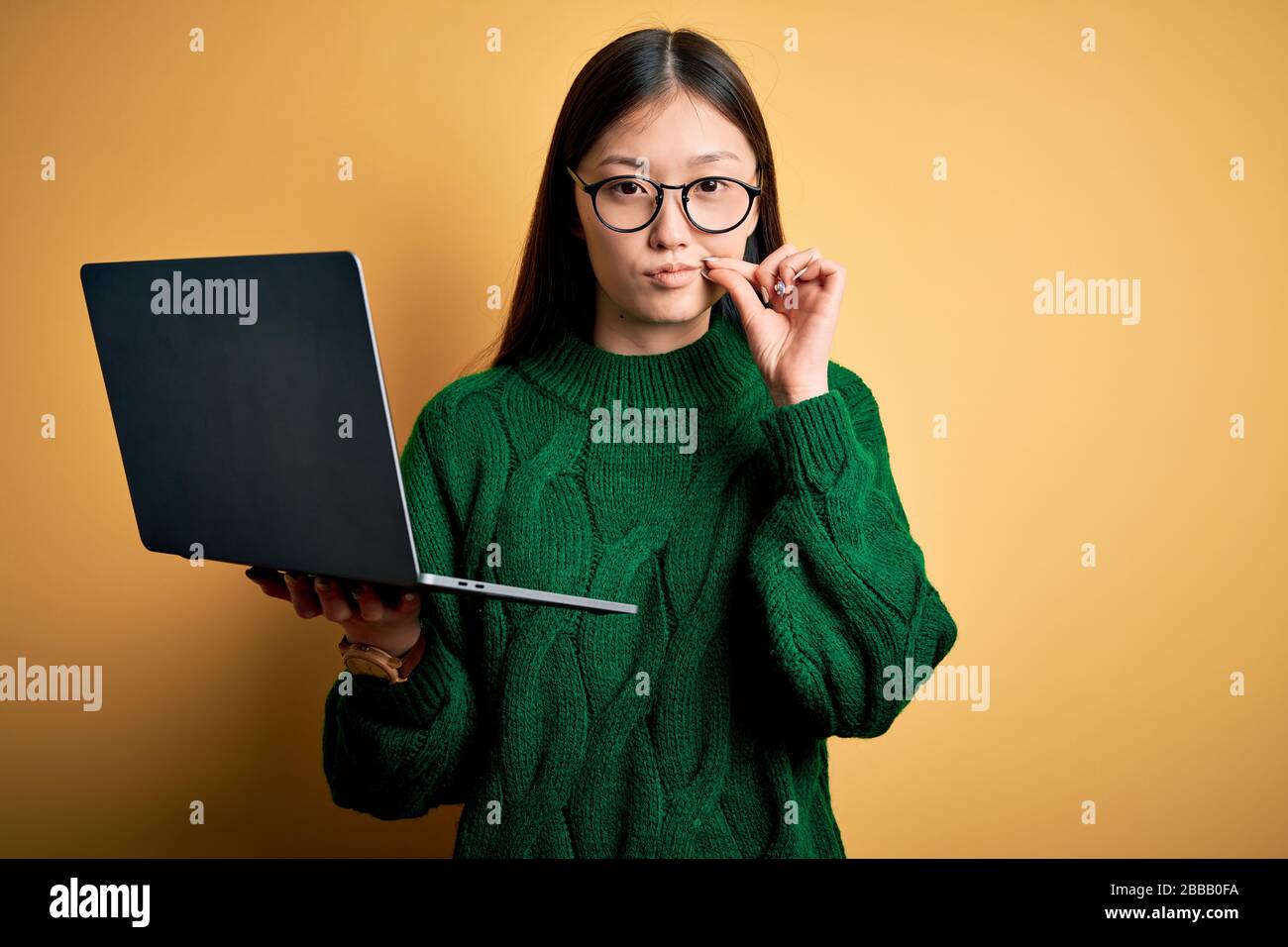 Young asian business woman wearing glasses and working using computer ...