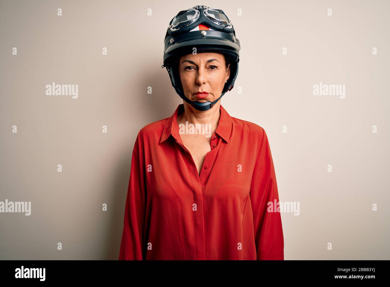 Middle age motorcyclist woman wearing motorcycle helmet over isolated ...