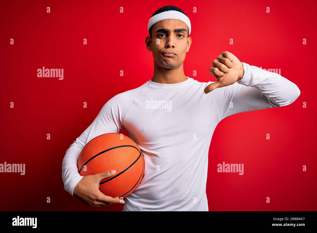 Young handsome african american sportsman holding basketball ball over ...