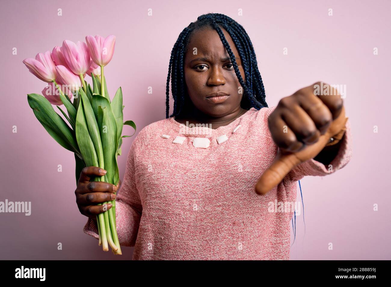 Young african american plus size woman with braids holding bouquet of ...