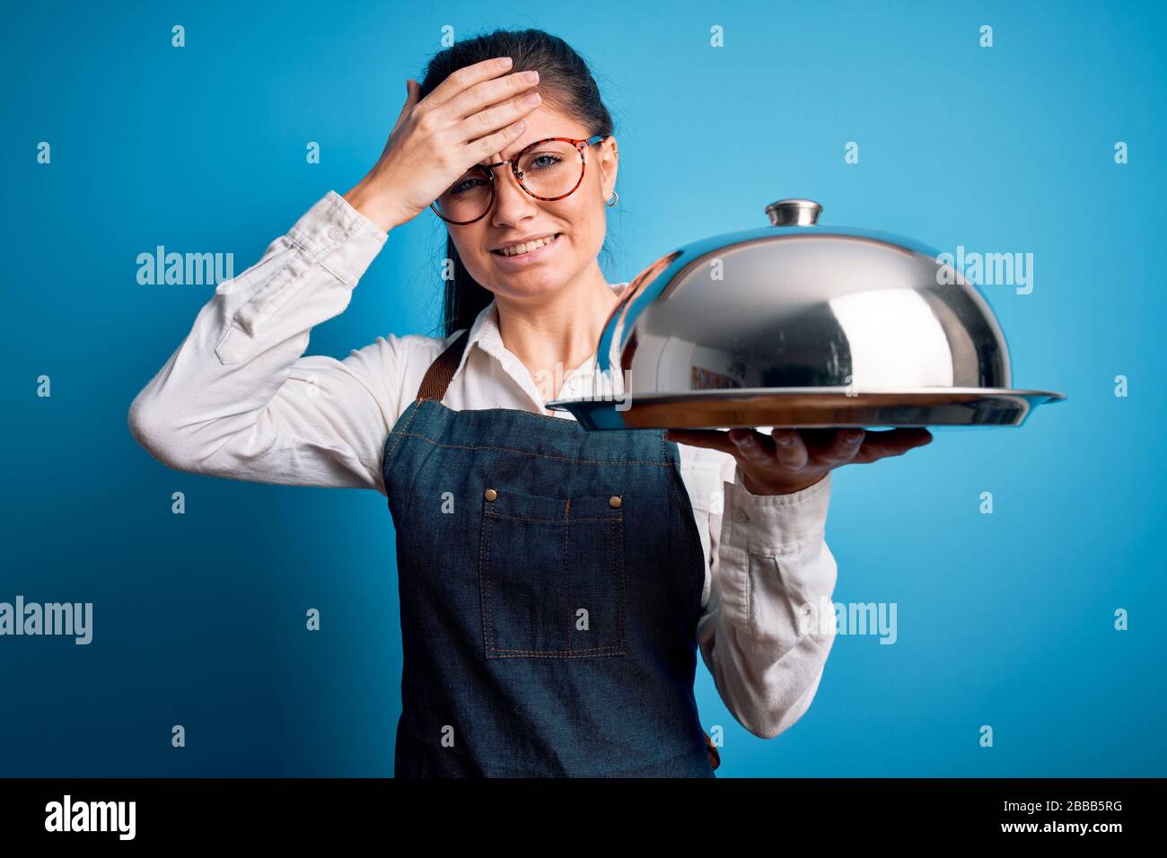 Young beautiful waitress woman with blue eyes holding tray with dome ...