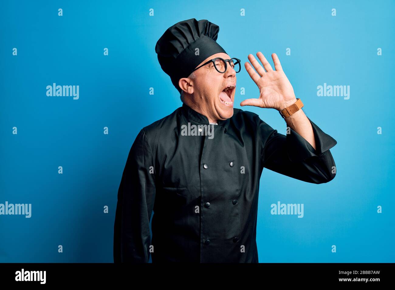Middle age handsome grey-haired chef man wearing cooker uniform and hat ...
