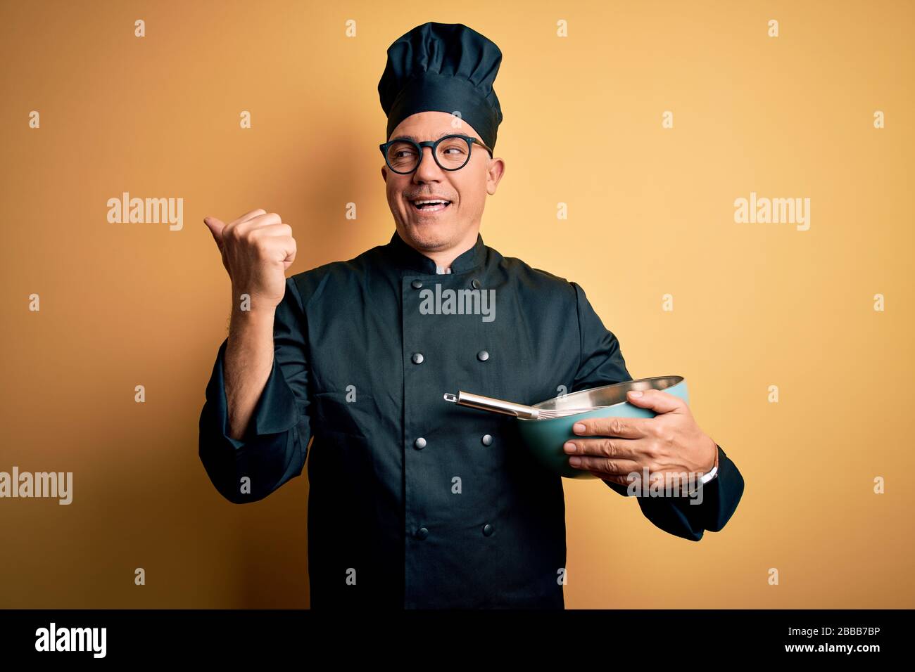 Middle age handsome grey-haired chef man wearing cooker uniform and hat ...